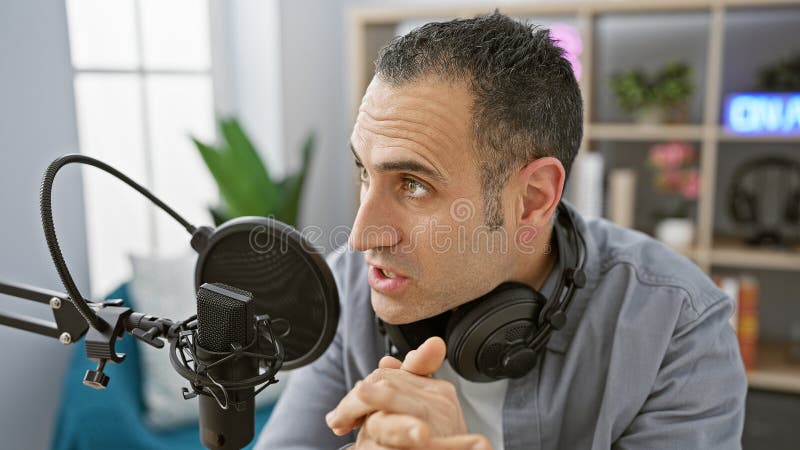 Hispanic Man Speaking into Microphone in a Radio Studio, Conveying ...