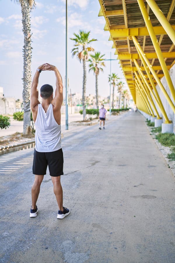 Hispanic Man Stretching after Working Out Outdoors on a Sunny Day Stock ...