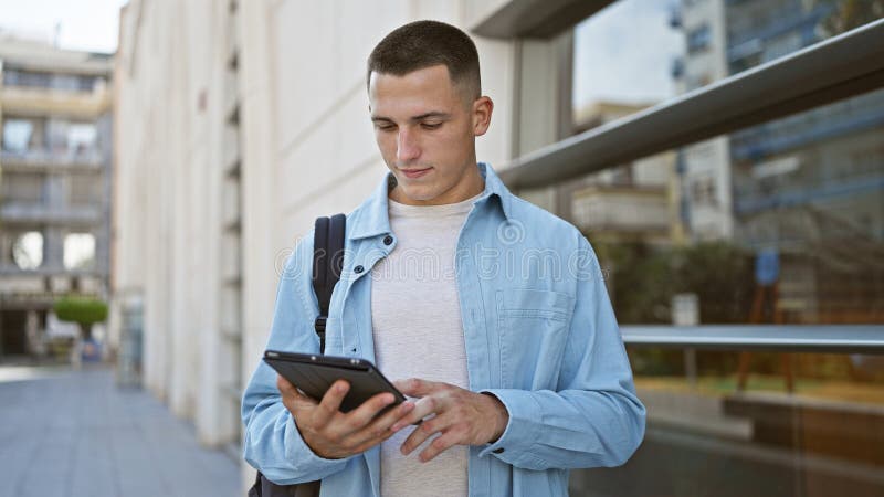 Hispanic Man Using Tablet on Sunny Urban Campus Street, Reflecting ...