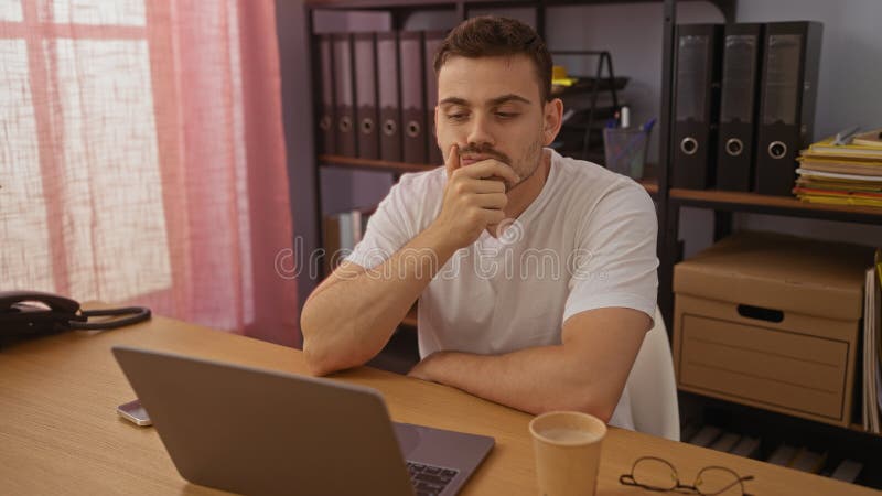 Hispanic Man Working Thoughtfully at His Desk in an Indoor Office ...