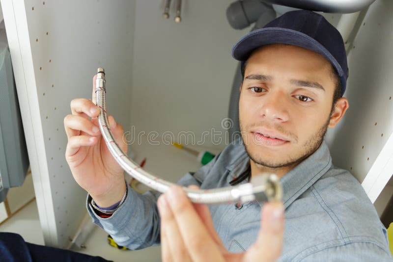 Hispanic Plumber Working Under Sink Stock Image - Image of smiling ...