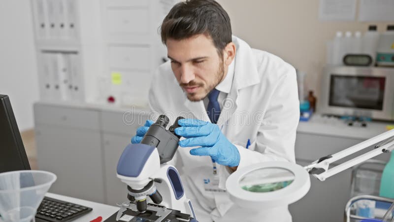 Hispanic Scientist Man Using Microscope in Medical Laboratory Stock ...