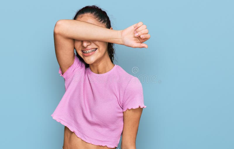 Hispanic Teenager Girl With Dental Braces Wearing Casual Clothes