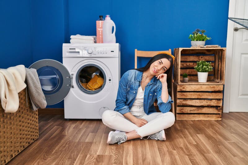 Hispanic Woman Doing Laundry Sitting on the Floor Serious Face Thinking ...