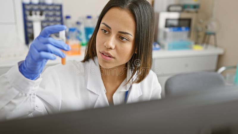 Hispanic Woman Scientist Analyzing a Sample in a Laboratory Setting, Wearing a Lab Coat and ...