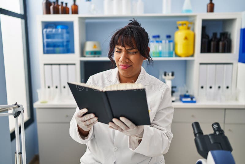 Hispanic Woman Working at Scientist Laboratory Reading a Book Clueless ...