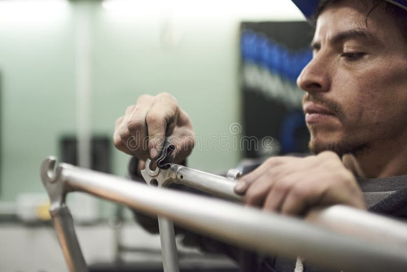 Hispanic Worker Sanding a Bicycle Frame at His Workshop Stock Image ...