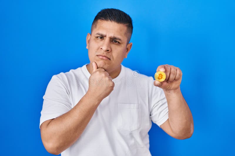 Hispanic Young Man Holding Virtual Currency Bitcoin Serious Face ...