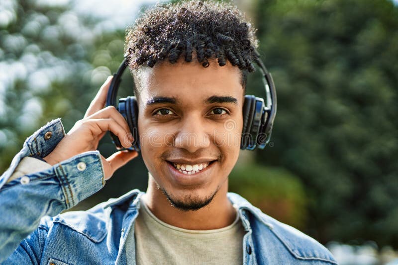 Hispanic Young Man Listening To Music Wearing Headphones At The