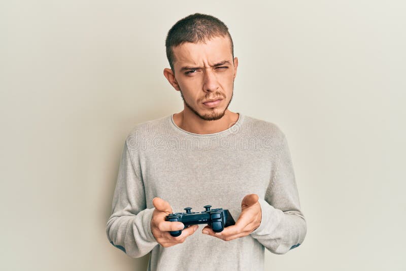 Hispanic Young Man Playing Video Game Holding Controller Clueless and ...