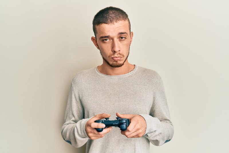 Hispanic Young Man Playing Video Game Holding Controller Depressed and ...