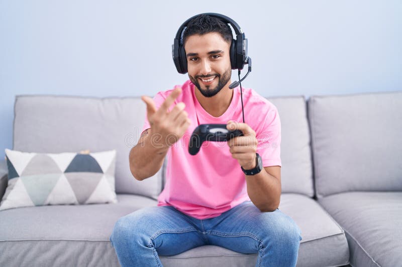 Hispanic Young Man Playing Video Game Holding Controller Sitting on the ...