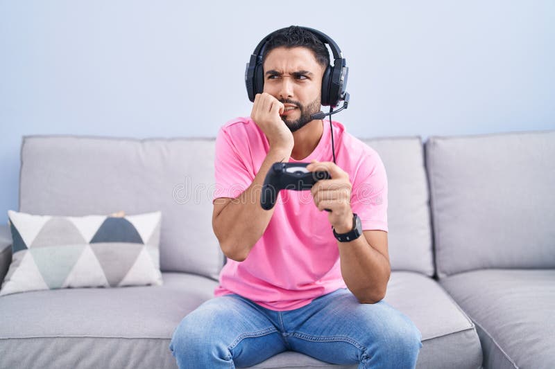 Hispanic Young Man Playing Video Game Holding Controller Sitting on the ...