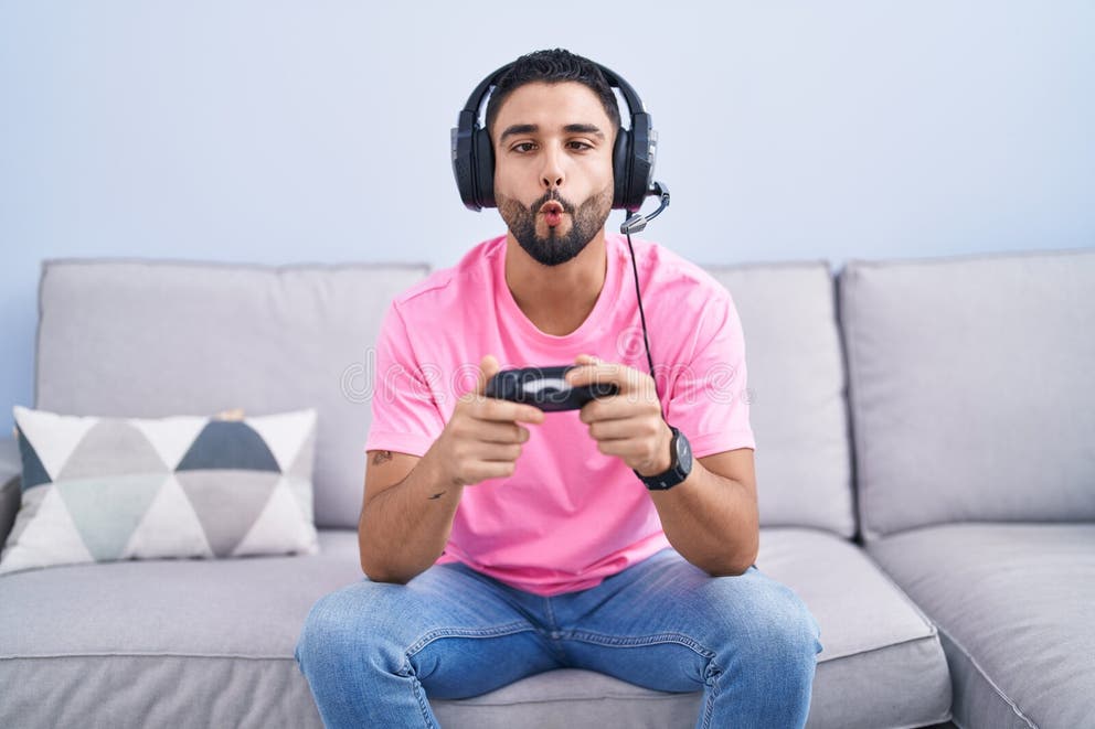 Hispanic Young Man Playing Video Game Holding Controller Sitting on the ...