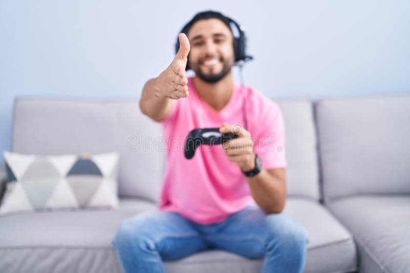 Hispanic Young Man Playing Video Game Holding Controller Sitting on the ...