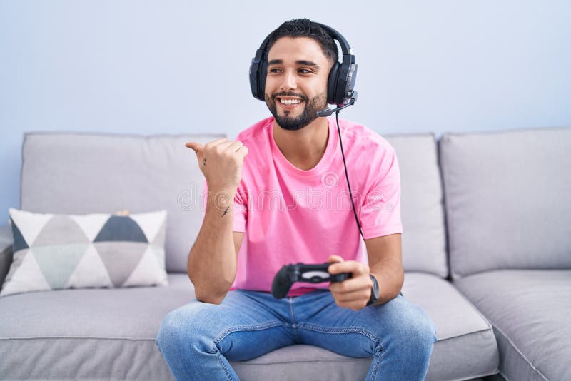 Hispanic Young Man Playing Video Game Holding Controller Sitting on the ...