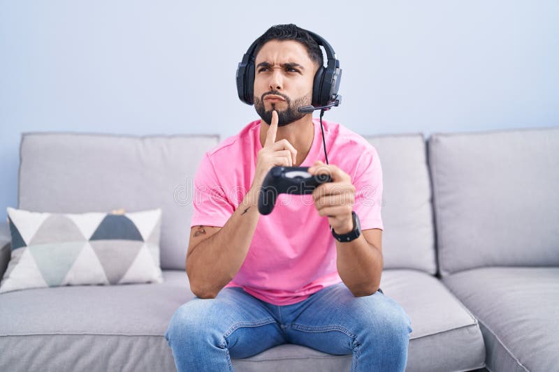 Hispanic Young Man Playing Video Game Holding Controller Sitting on the ...