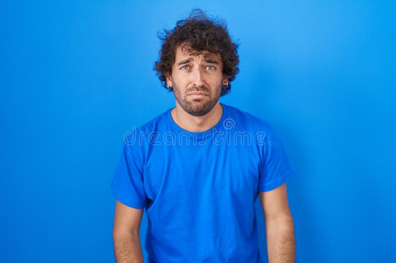 Hispanic Young Man Standing Over Blue Background Depressed and Worry ...