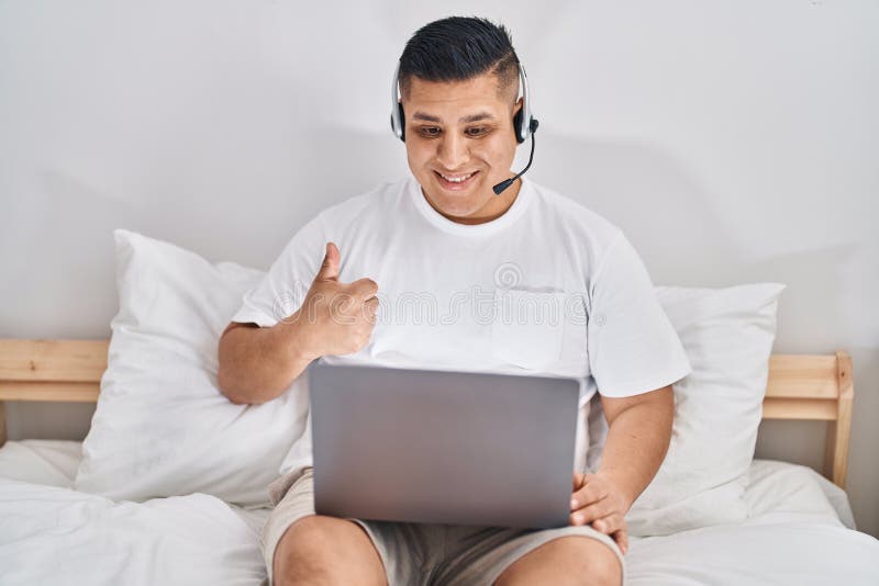 Hispanic Young Man Using Computer Laptop on the Bed Smiling Happy and ...