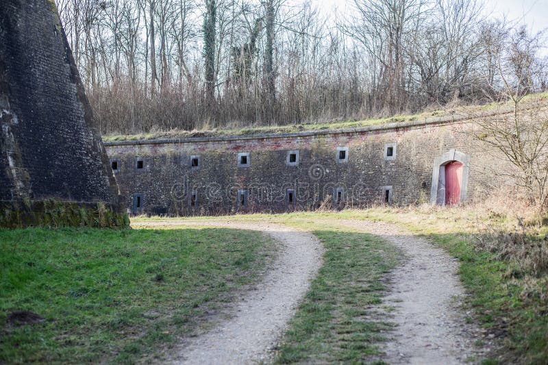 Historic Brick Fort with Pathway and Red Door in Overgrown Landscape ...