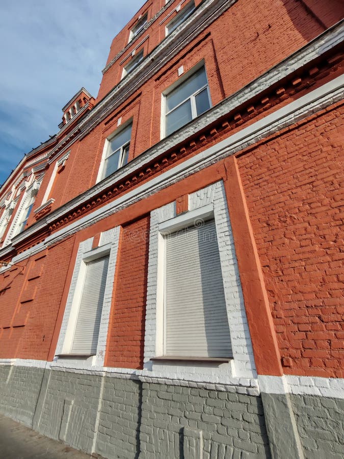 A Historic Facade with Red Bricks and Two Windows Equipped with ...