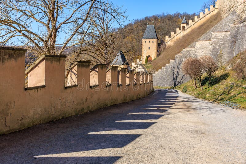 Historic Karlstejn Castle Pathway with Stone Walls and Trees in Bright ...