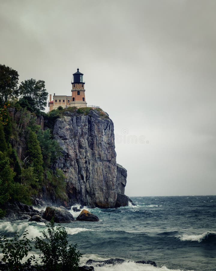 Historic Lighthouse Perched on the Cliff Overlooking Rough Waters Stock ...