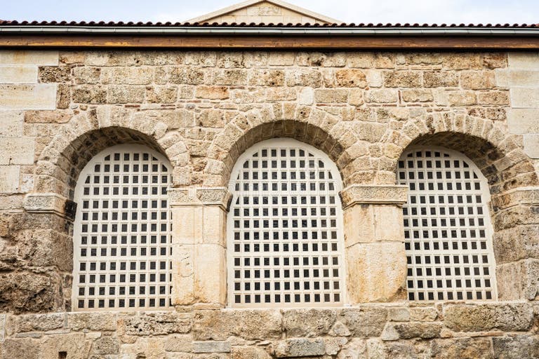 Historic Stone Building with Three Arched Windows and Grids Stock Photo ...