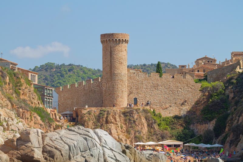 A Historic Stone Castle Tower Overlooking a Beach, Surrounded by Rocky ...