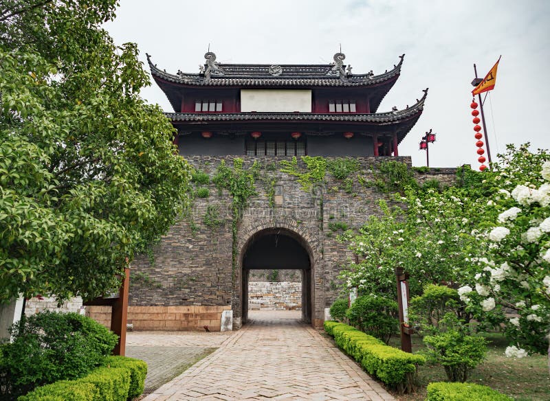 Historic Stone Gate Covered in Greenery with Traditional Architecture ...