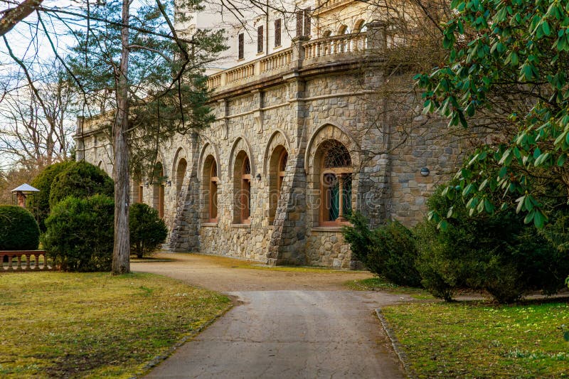 Historic Stone Mansion with Arched Windows and Lush Garden in Tranquil ...