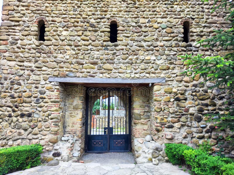 Historic Stone Wall Entrance with a Decorative Gate Surrounded by ...