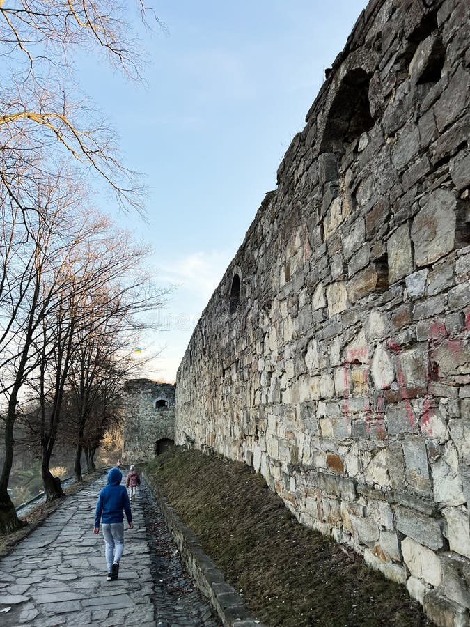 Historic Stone Wall in Winter with People Walking Along the Pathway ...