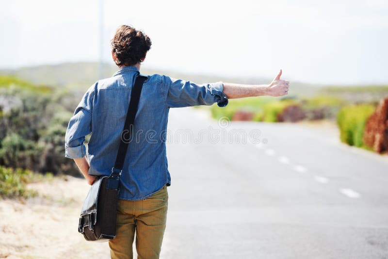 Hitching a Ride. Rear-view of a Young Man Hitchhiking on the Side of ...