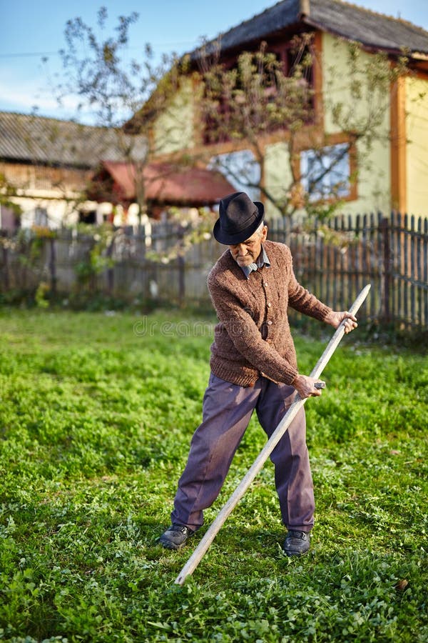 Boer Die Groot Gras Maait in Een Dorp in De Achtertuin Met Een Maaier ...