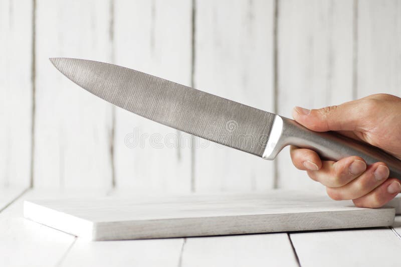 Holding Casting Steel Chef Knife in Hand on Cutting Board Stock Photo ...