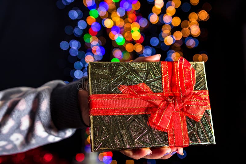 Holding Christmas Gift Isolated on Background with Blurred Lights ...