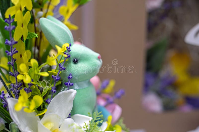 Holding a Cute Blue Easter Bunny in Decorative Flowers. Stock Photo ...