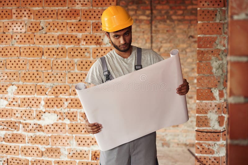 Showing and Holding Little Shovel and Brick. Handsome Indian Man is on ...