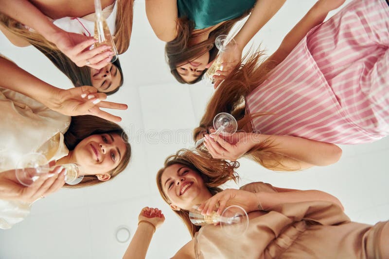 Holding Drinks and Looking Down. Group of Happy Women that is at a ...