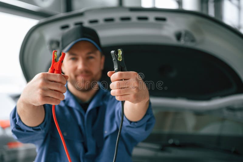 Holding the Electrical Terminals. Man in Blue Uniform is Working in the ...