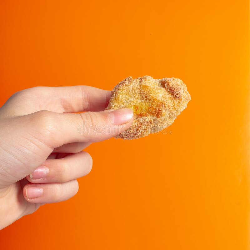 Holding a Fried Snack Chicken Nuggets on an Orange Background in Your ...