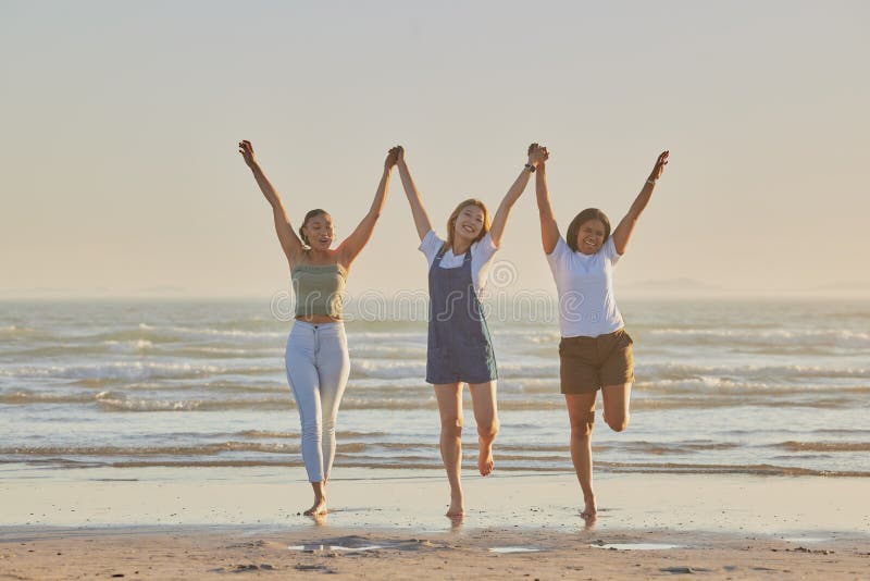 Holding Hands Friends And Women On Beach Jump Together And Bonding Or