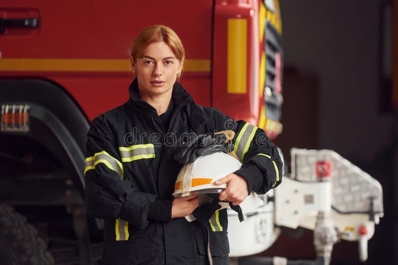 Holding Helmet. Woman Firefighter in Uniform is at Work in Department ...