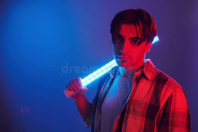Holding Lighting Equipment. Man Standing in the Studio with Neon Stock ...