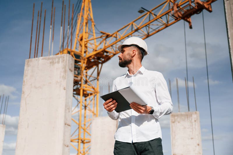 Holding Notepad. Man in Uniform is Working on the Construction Site ...