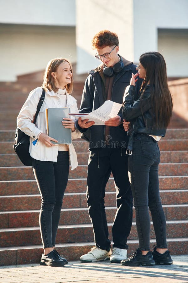 Holding Notepads in Hands. Three Young Students are Outside the ...