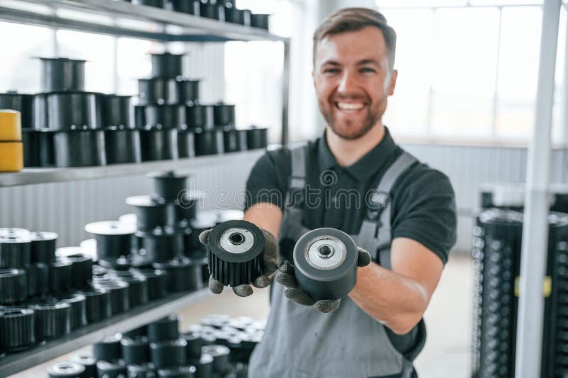 Holding Objects and Smiling. Man in Uniform is in Workstation ...