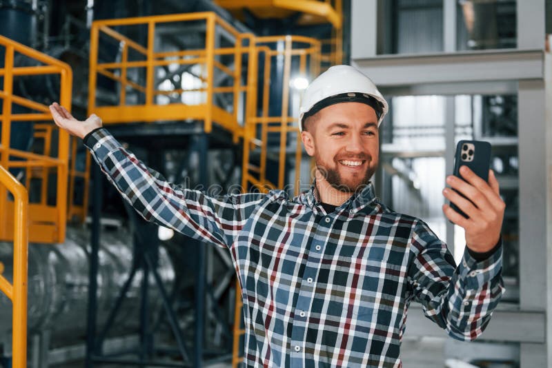 Holding Phone. Construction Worker in Uniform is in the Factory Stock ...