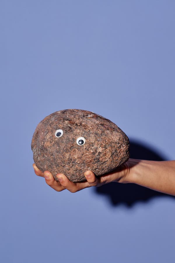 Holding Rock with Googly Eyes on Neutral Background Stock Image - Image ...